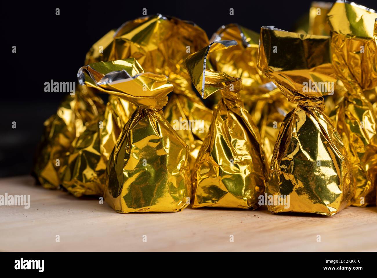 Packed in golden foil truffle candy on the board, a large number of ...