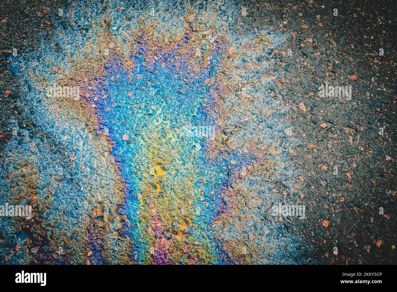 Rainbow gasoline oil spill on the pavement as a texture or background ...