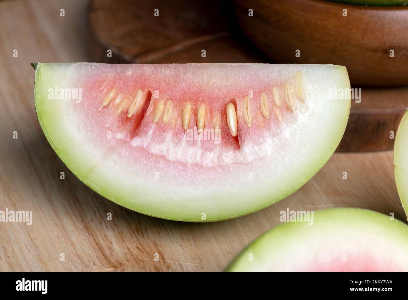 cut small unripe watermelon on a board, cut into pieces unripe ...