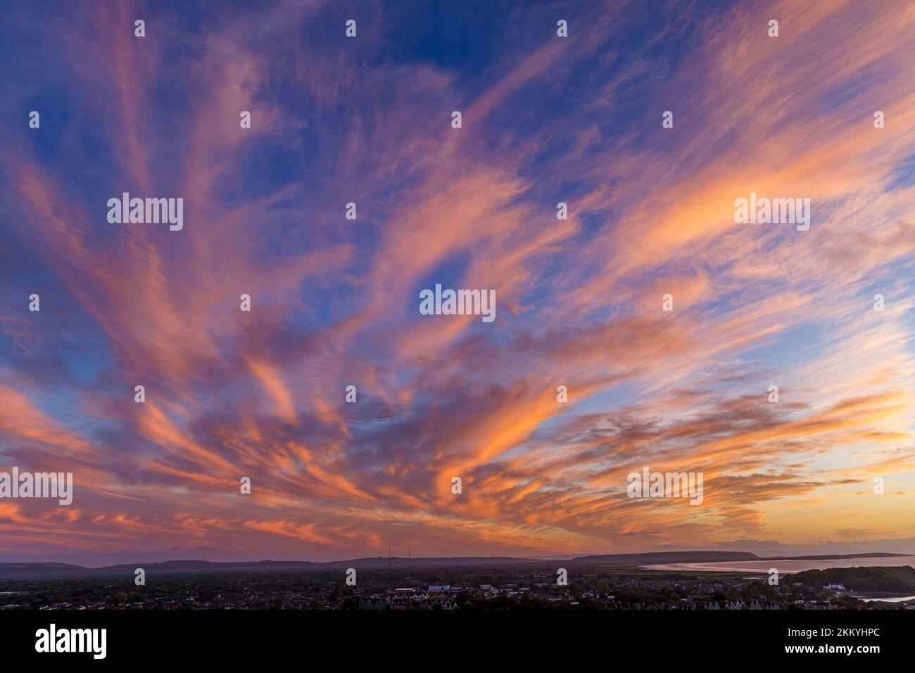 A pinkish hue lighting up the underside of the cloud cover Stock Photo ...