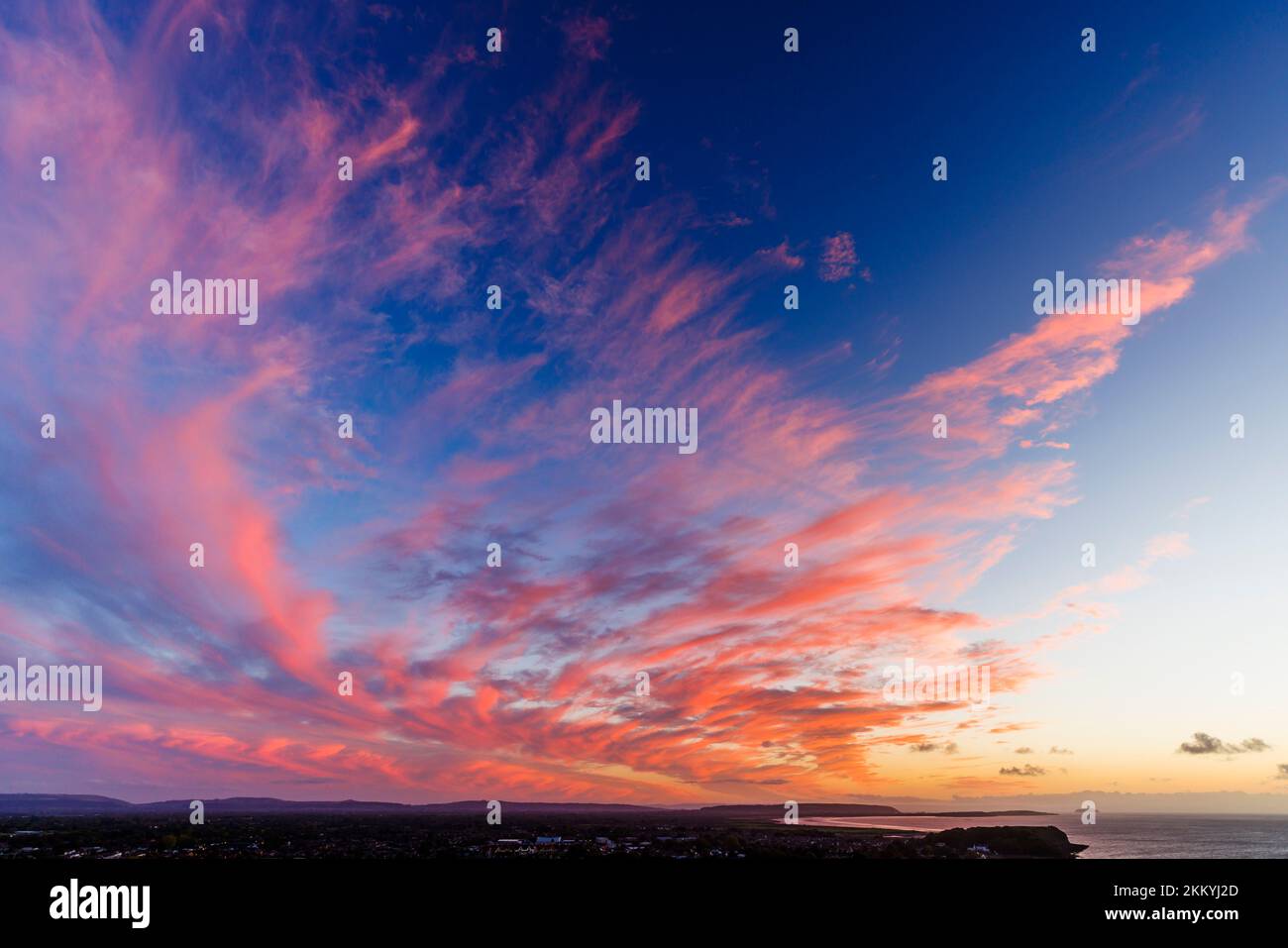 A pinkish hue lighting up the underside of the cloud cover Stock Photo ...