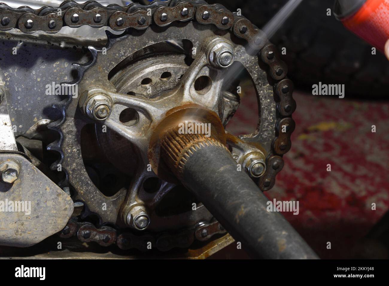 Applying an unclogging liquid in the driveshaft of a quad Stock Photo ...