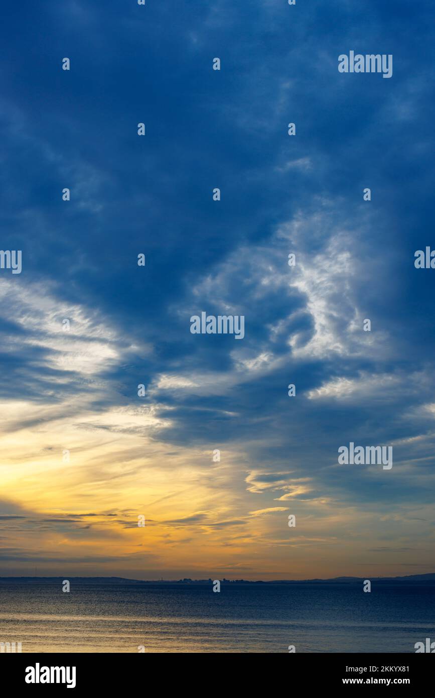 The setting sun lighting up the cloud on the horizon Stock Photo - Alamy