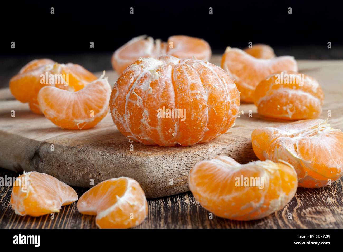peeled ripe juicy tangerine, divided into slices of tangerine on a ...
