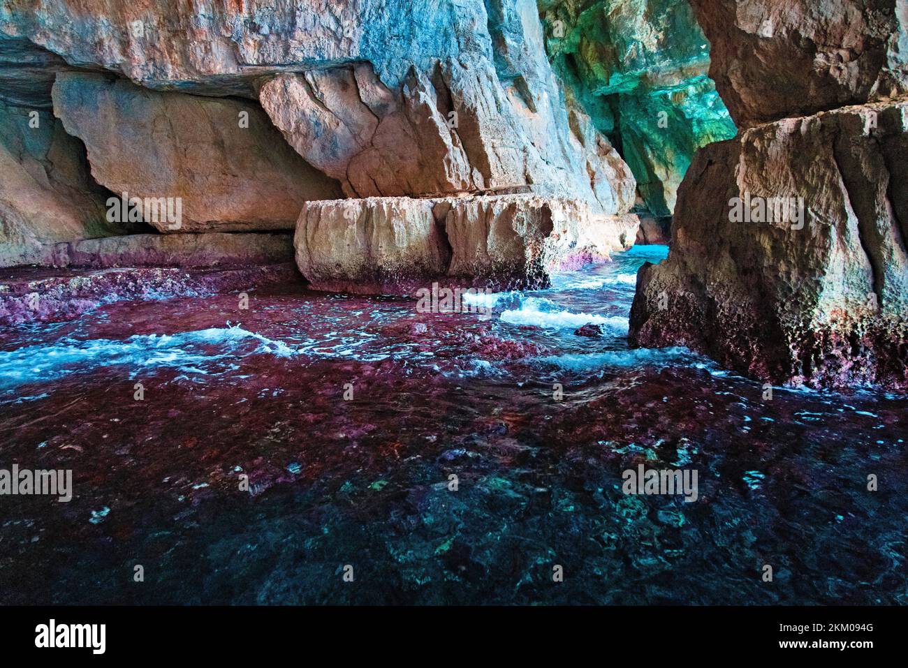 The turquoise water surrounding the rock formations of Blue Grotto sea ...