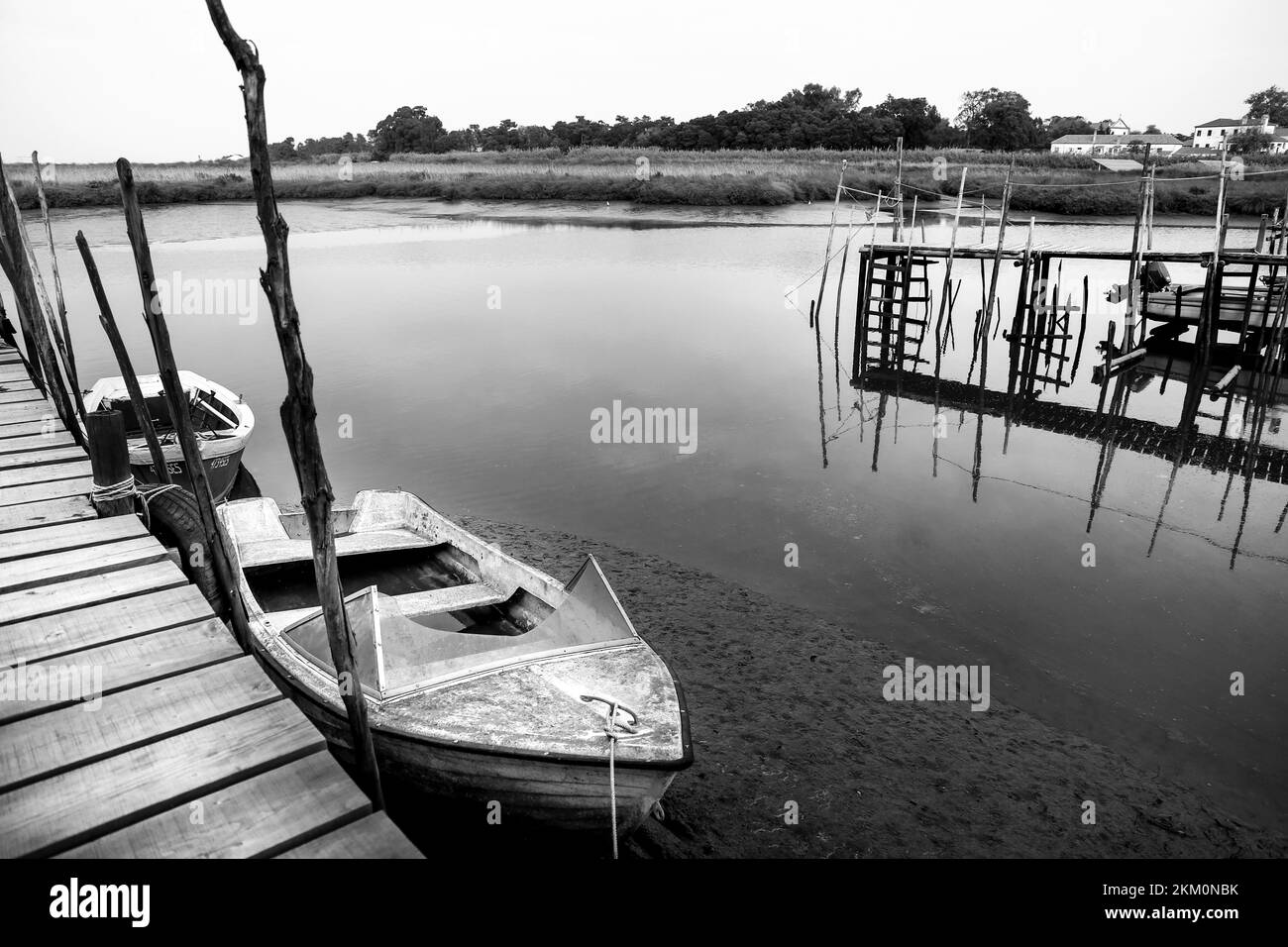 Old Fishing boats docked in a port with a wooden walkway in ...