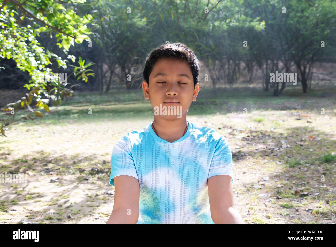 An indian boy doing yoga outdoors Stock Photo - Alamy