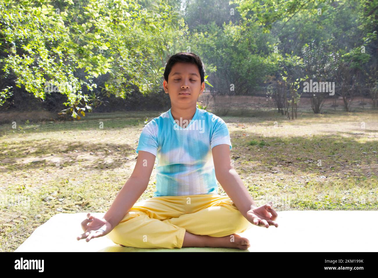 An indian boy doing yoga outdoors Stock Photo - Alamy
