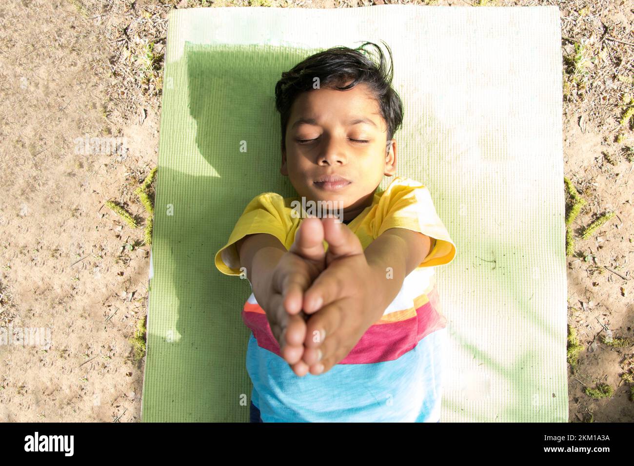Young Boy doing yoga with hands outstretched Stock Photo - Alamy