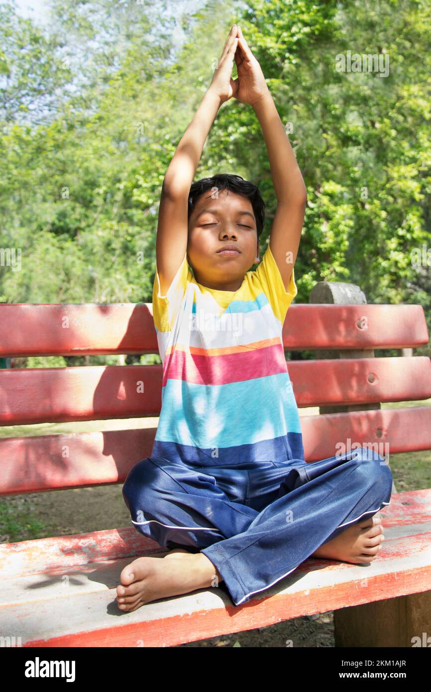 Indian Boy meditating in prayer position at park Stock Photo - Alamy