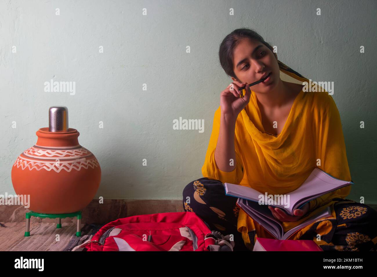 Teenage girl thinking while studying at home Stock Photo - Alamy