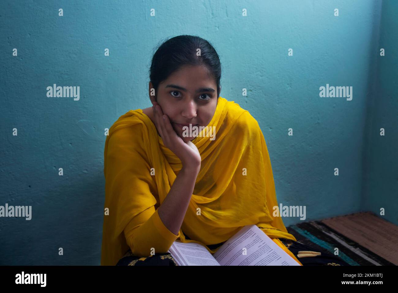 A girl in school uniform thinking while studying at home Stock Photo ...