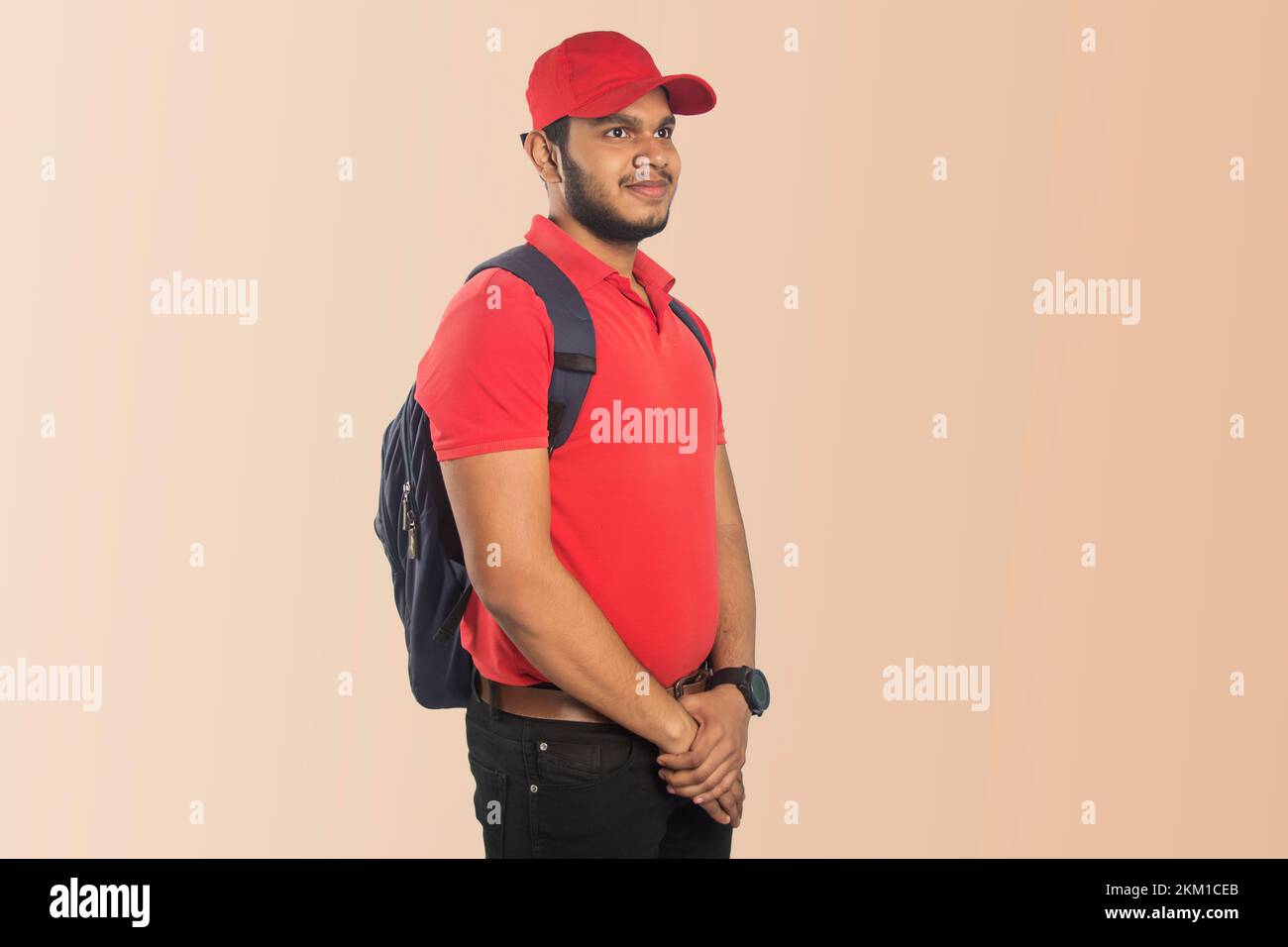 Portrait of a confident young delivery man standing with arms folded ...