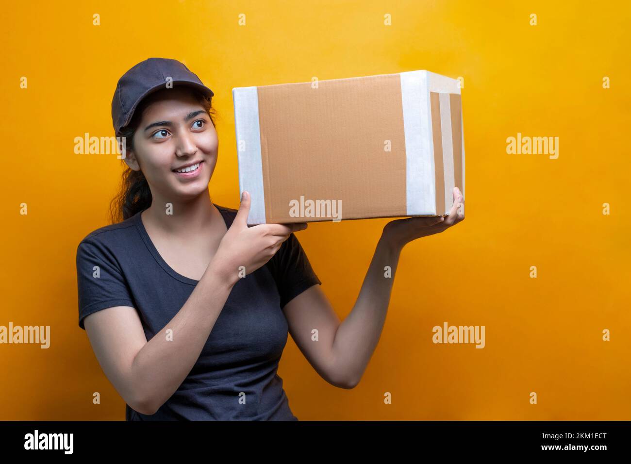 Portrait Of Young Delivery Woman Carrying Cardboard Box On Shoulder ...