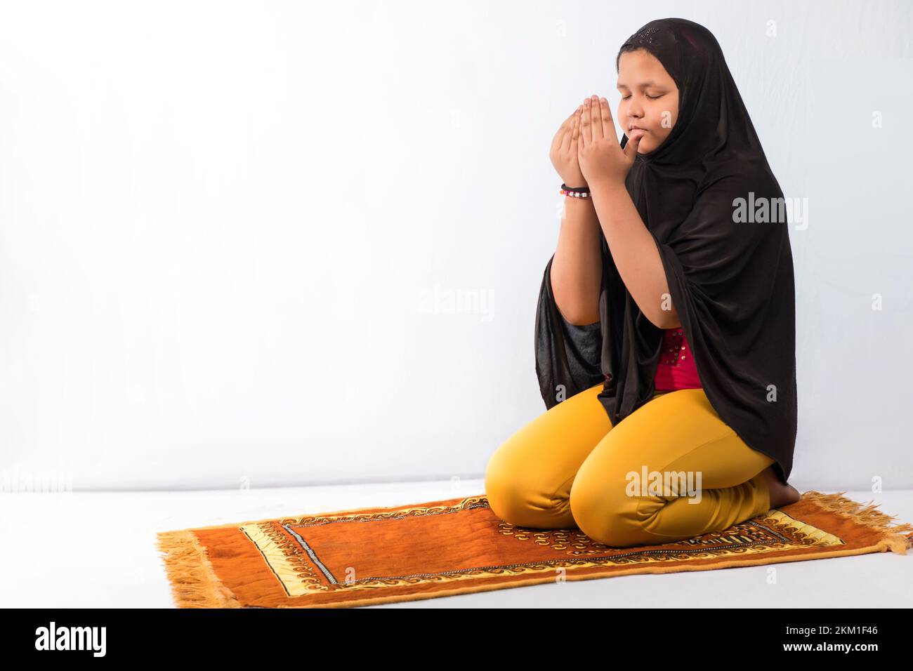 Asian Islam or Muslim child girl wearing a hijab is reading the book ...