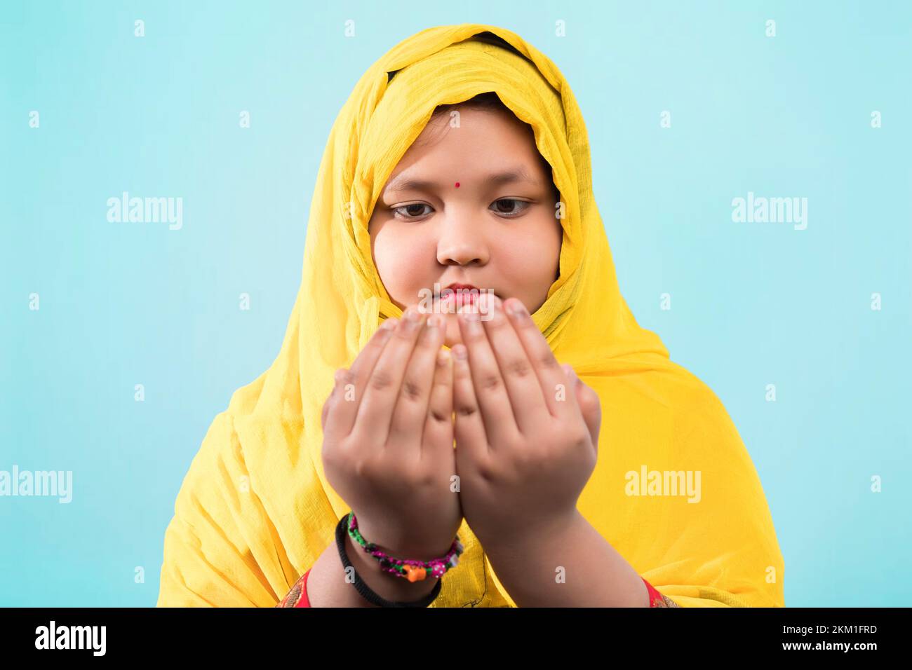 A religious Asian Muslim child girl in the Muslim hijab dress is ...
