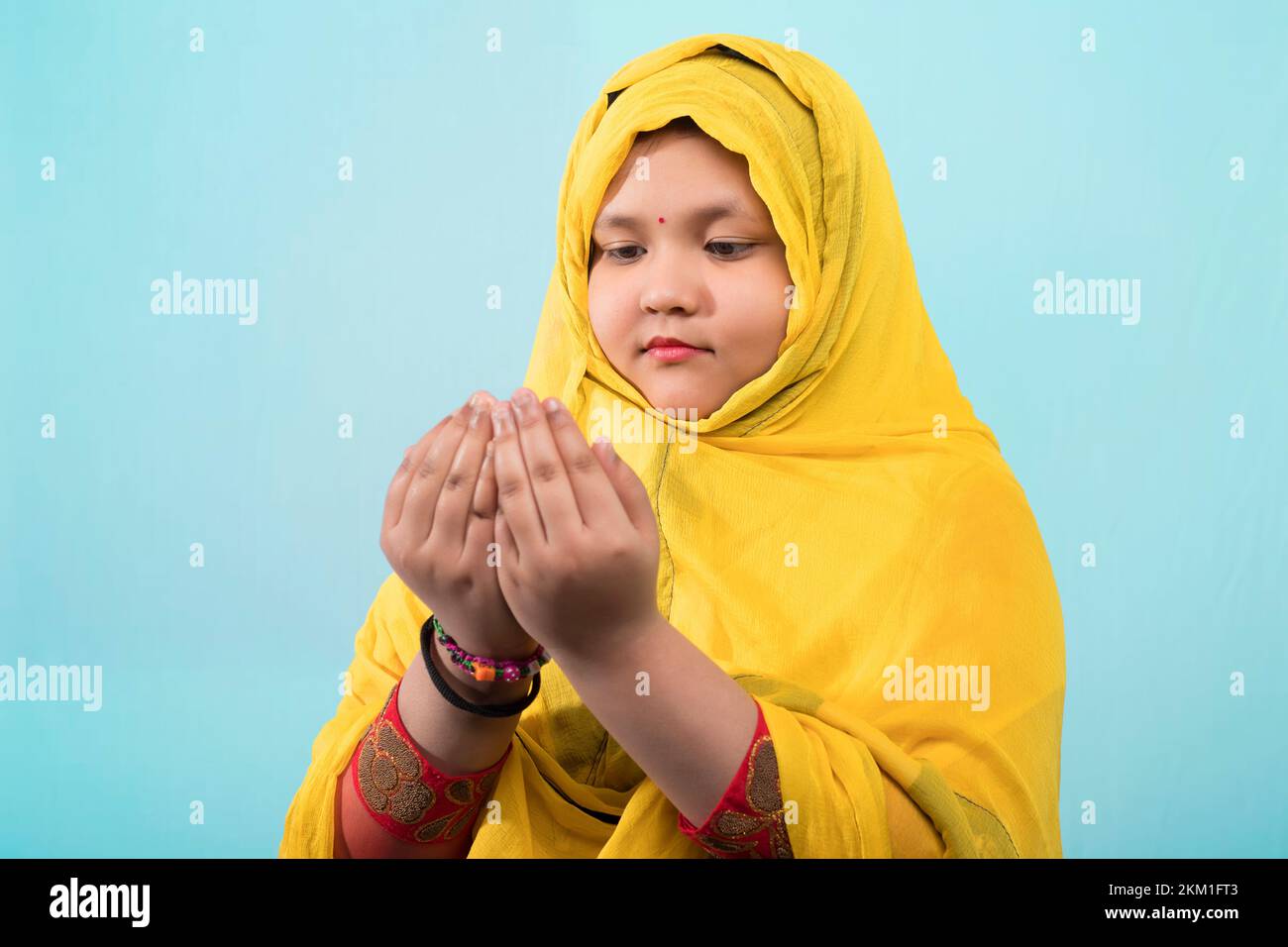 A religious Asian Muslim child girl in the Muslim hijab dress is ...