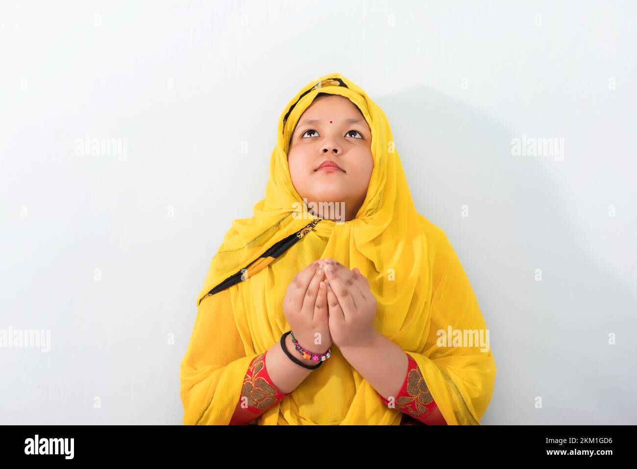 A religious Asian Muslim child girl in the Muslim hijab dress is ...