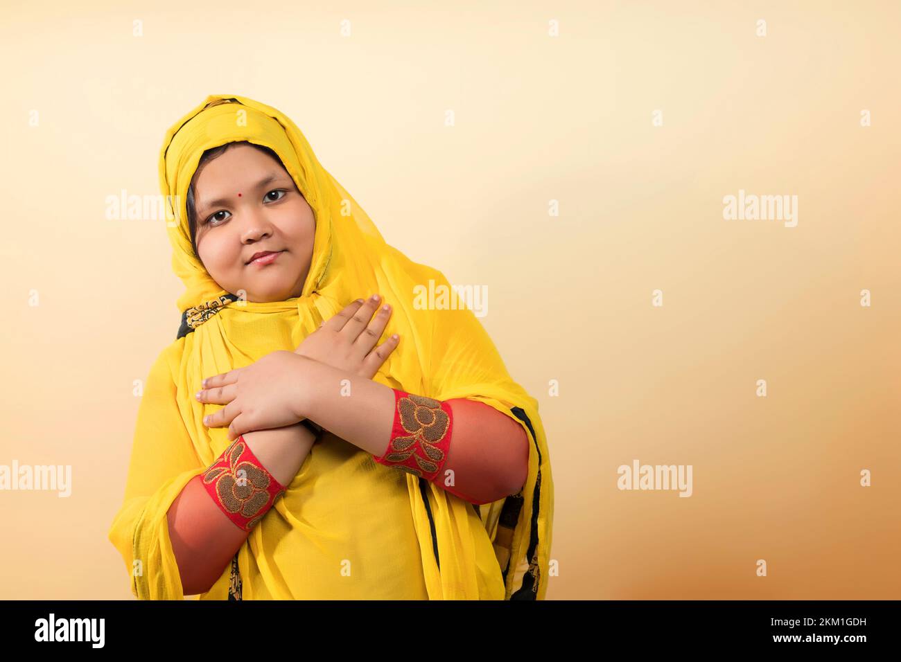 A religious Asian Muslim child girl in the Muslim hijab dress is ...