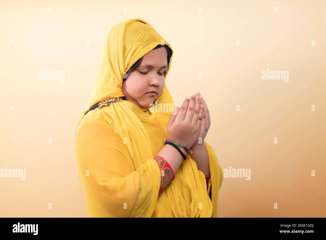 A religious Asian Muslim child girl in the Muslim hijab dress is ...