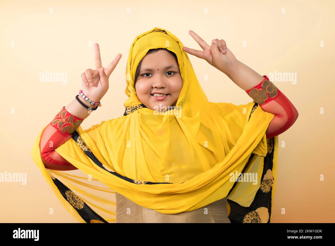 Beautiful asian muslim girl in hijab showing peace or victory hand ...