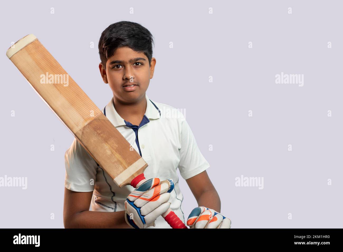 A boy in cricket uniform holding Cricket Bat Stock Photo - Alamy