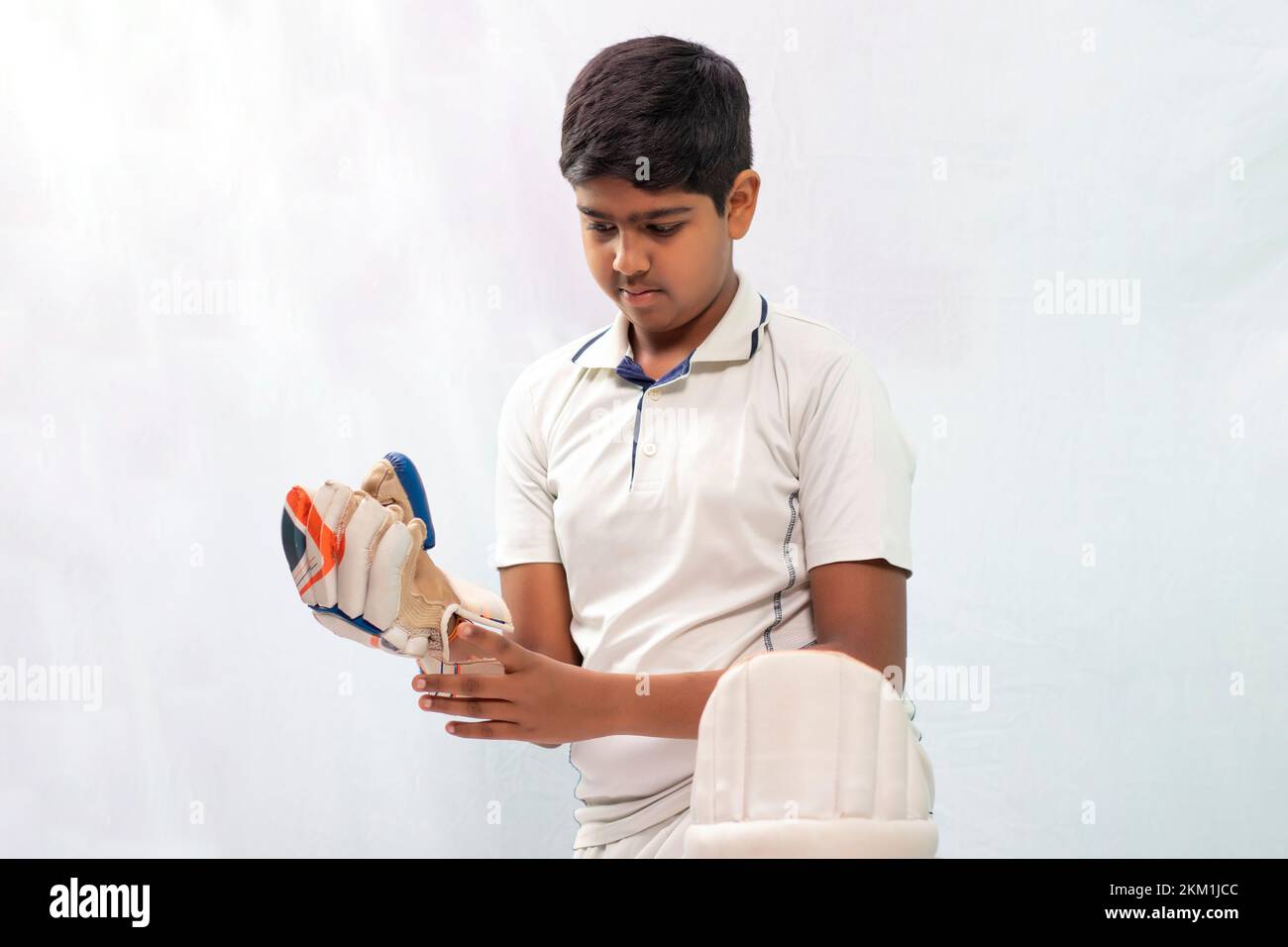 Portrait of young Indian boy wearing hand gloves and getting ready for ...