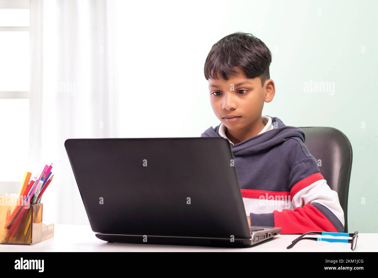 Indian kid doing homework computer hi-res stock photography and images ...