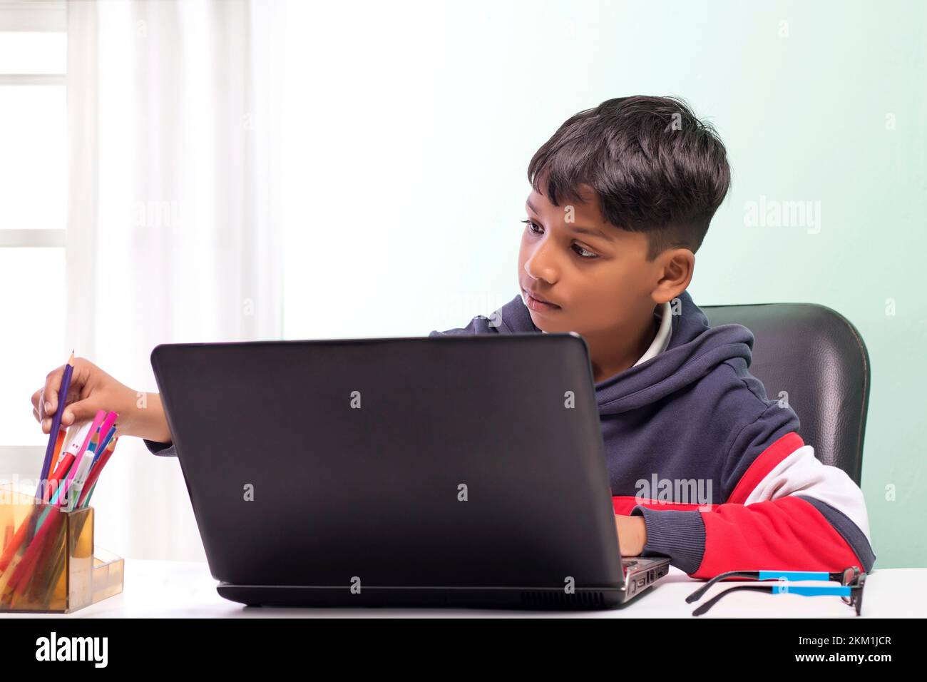 Indian kid doing homework computer hi-res stock photography and images ...