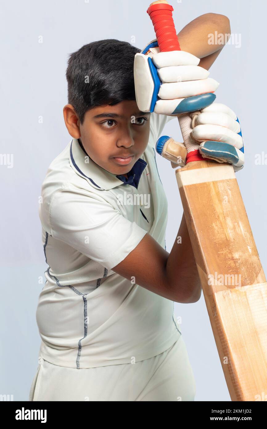 A boy in cricket uniform playing Cricket Stock Photo - Alamy