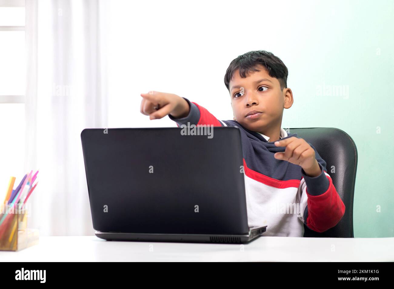 Young Boy using Laptop raised his hand Stock Photo - Alamy