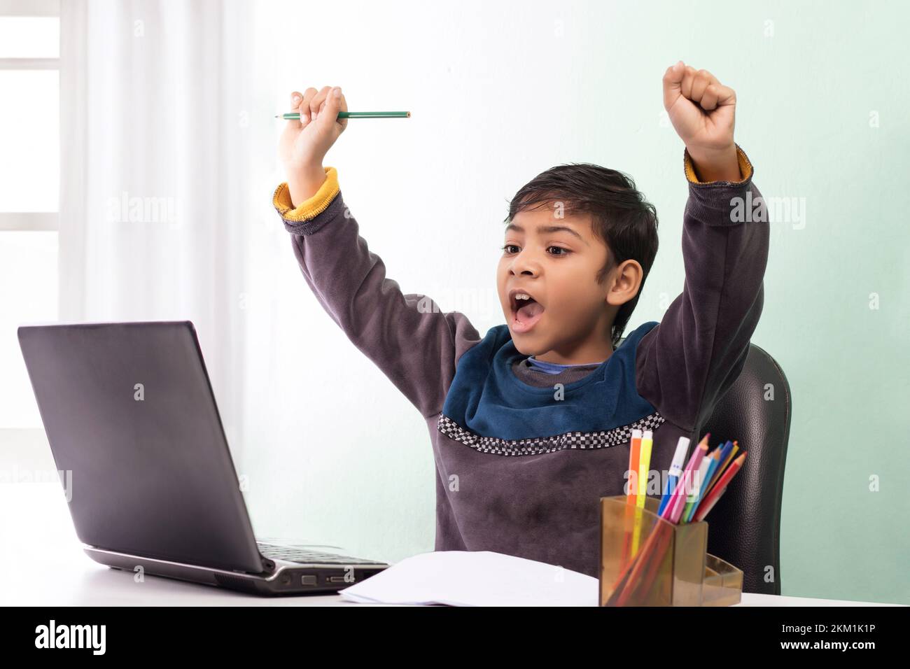 Boy using laptop and waving during video call while homeschooling Stock ...
