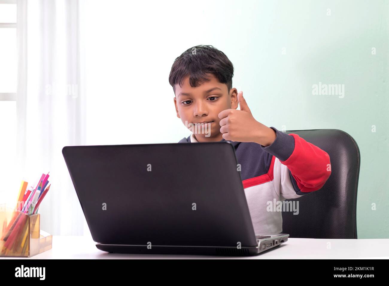 Young Boy using Laptop Showing Thumbs Up Stock Photo - Alamy