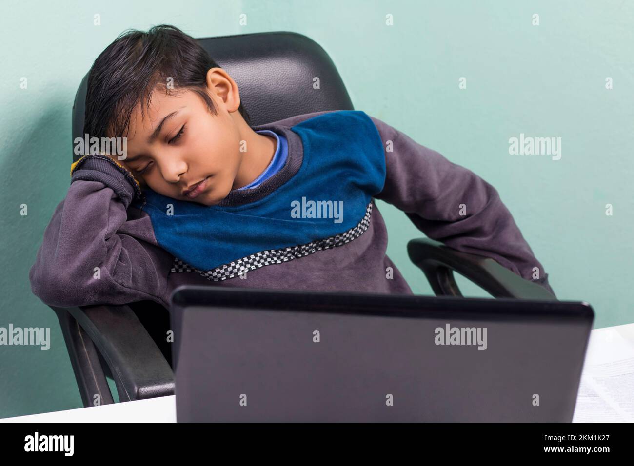 Photo of a Young boy sleeping in front of a laptop computer and on a ...