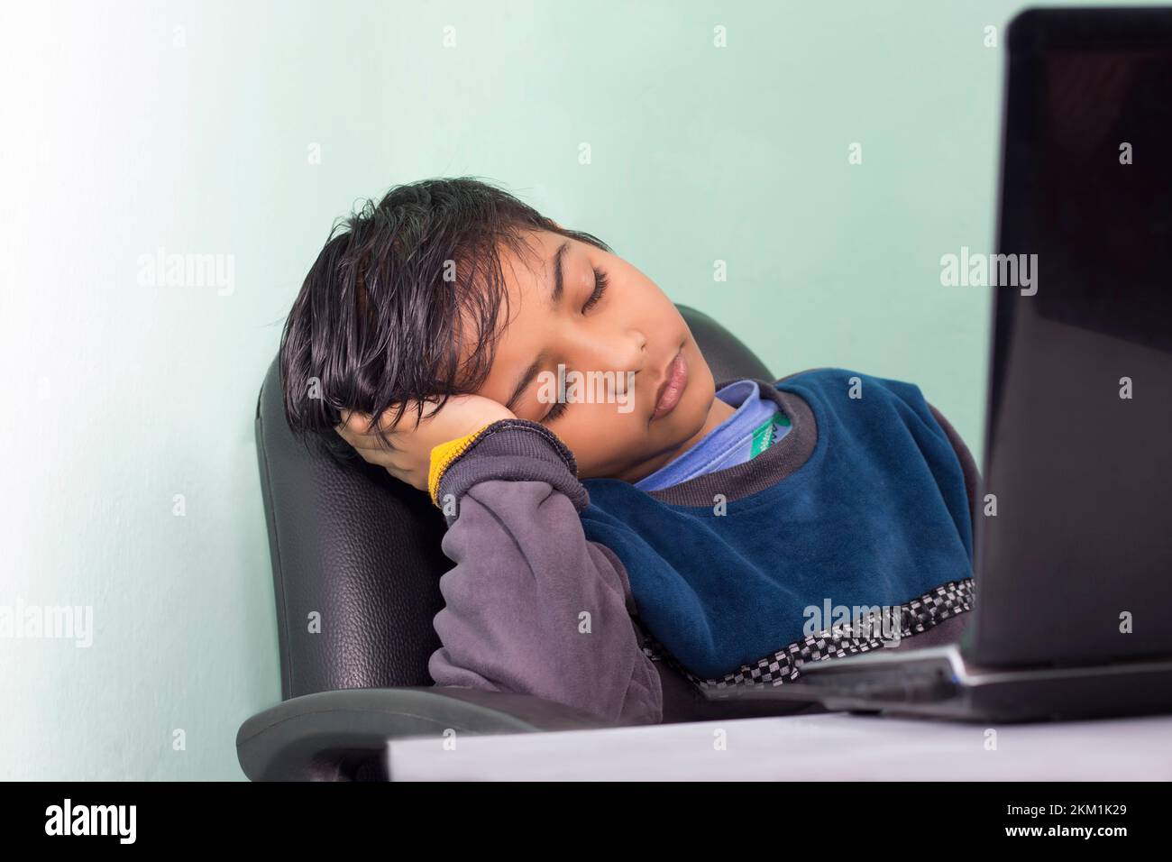 Photo of a Young boy sleeping in front of a laptop computer and on a ...