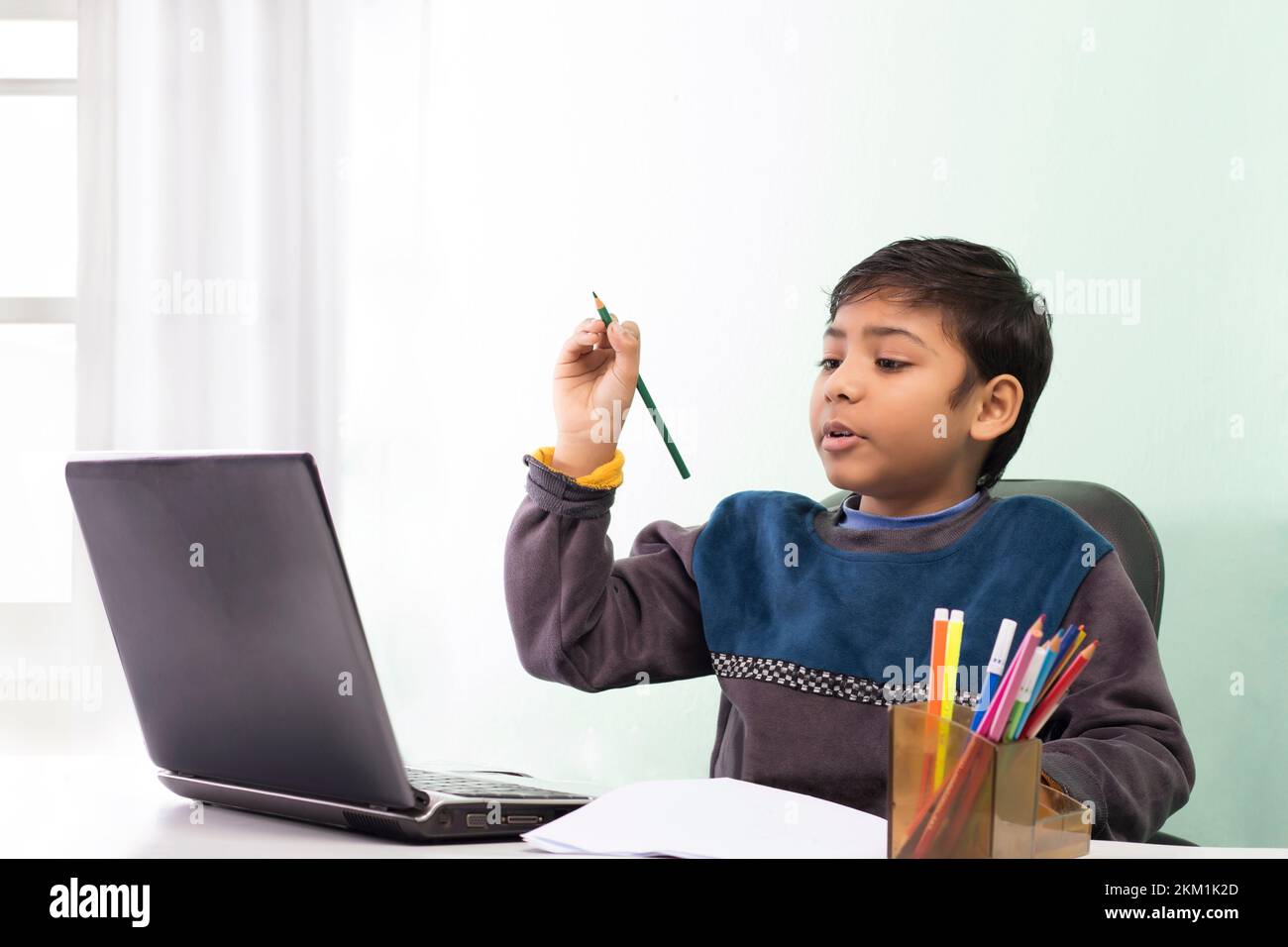 Boy using laptop and waving during video call while homeschooling Stock ...