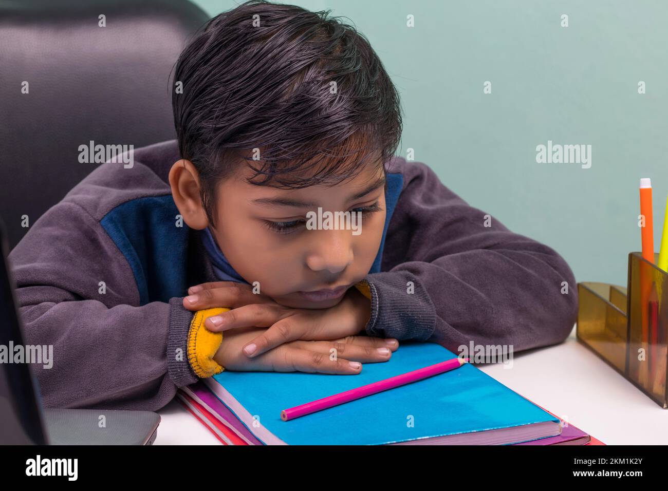 a boy laying down on table and thinking Stock Photo - Alamy