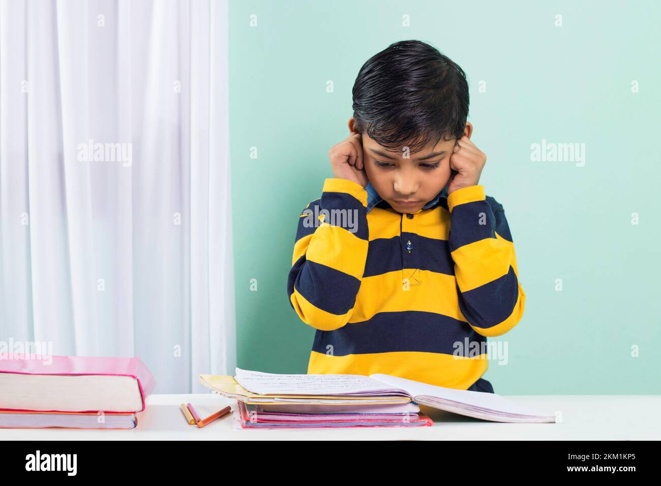 Punished schoolboy holding his ears feeling sorry Stock Photo - Alamy