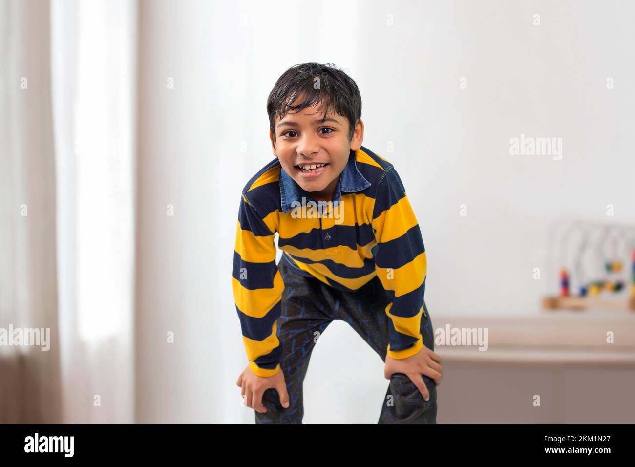 An Indian boy bending forward and looking At Camera Stock Photo - Alamy