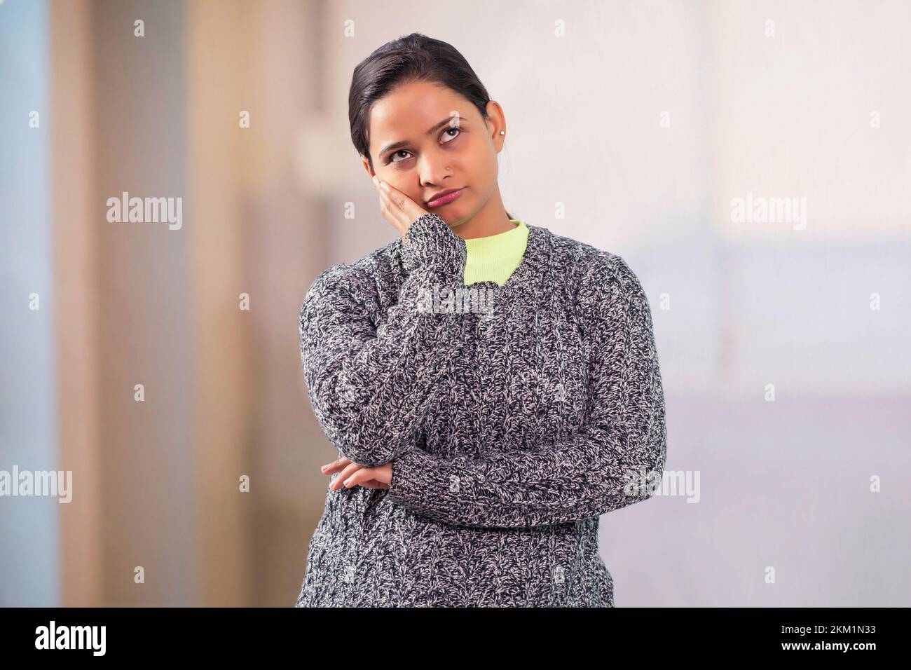 Cheerful young adult indian woman hand on chin and thinking Stock Photo ...