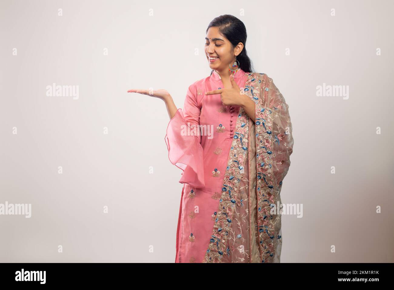 young Teenager girl smiling and pointing sideways Stock Photo - Alamy