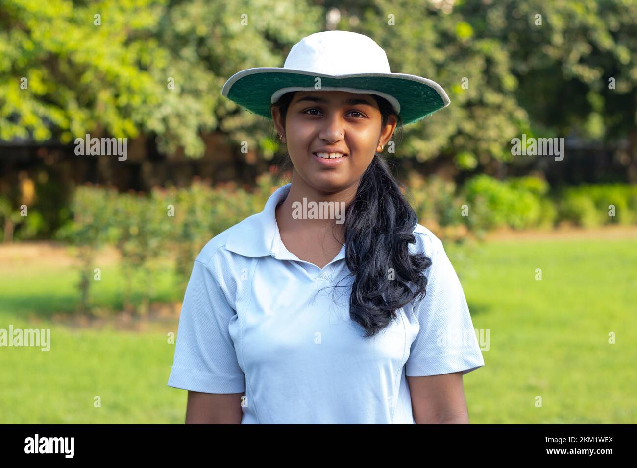 a girl wearing cricket uniform and cap standing in outdoor Stock Photo ...