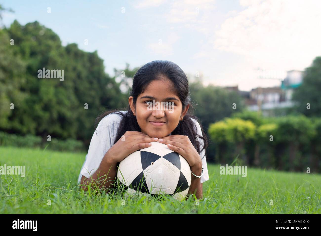 A young girl posing with her soccer ball on the outfield Stock Photo ...