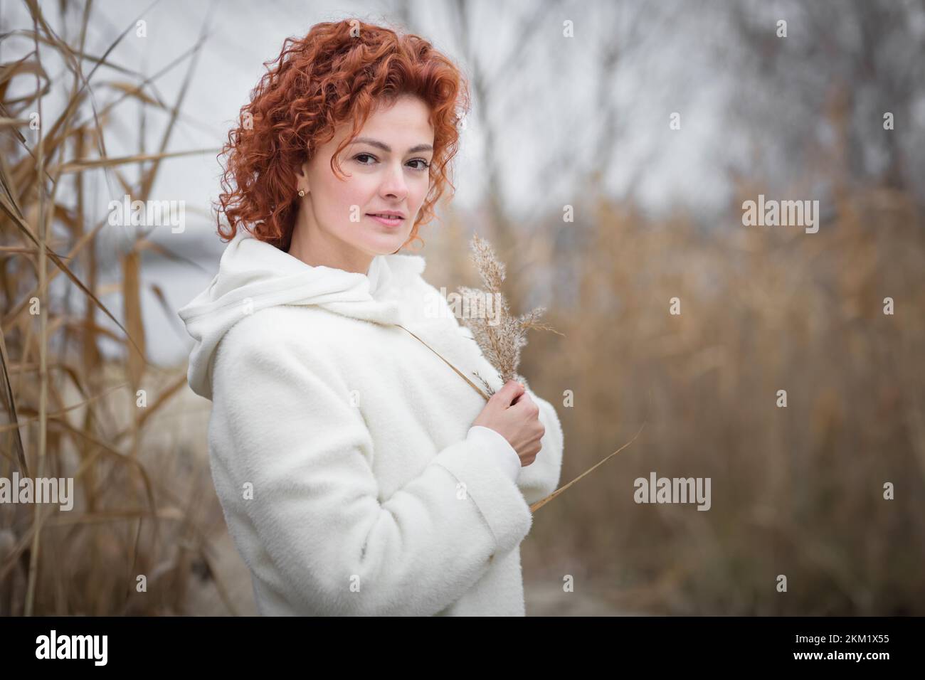 Attractive stylish woman holding dry reed walking in park Stock Photo ...