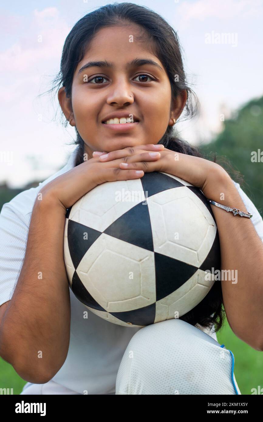 A young girl posing with her soccer ball on the outfield Stock Photo ...