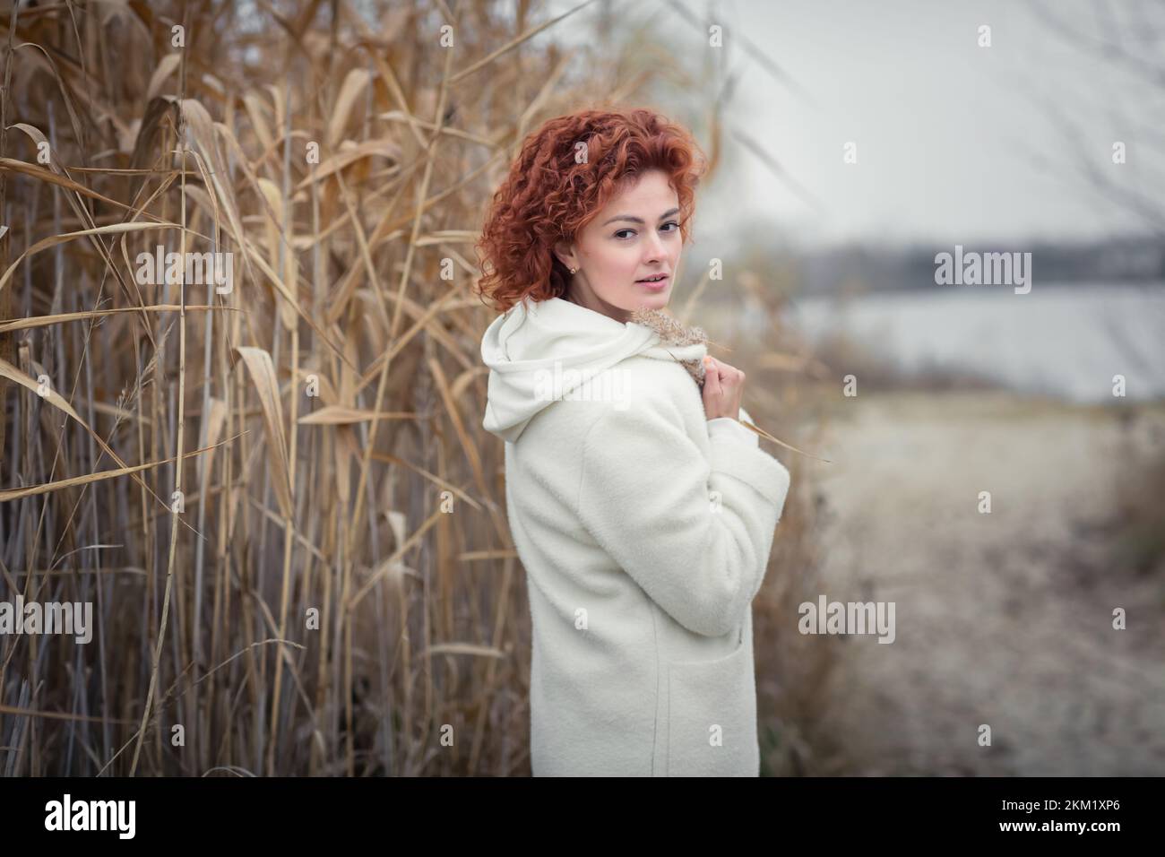Attractive stylish woman holding dry reed walking in park Stock Photo ...