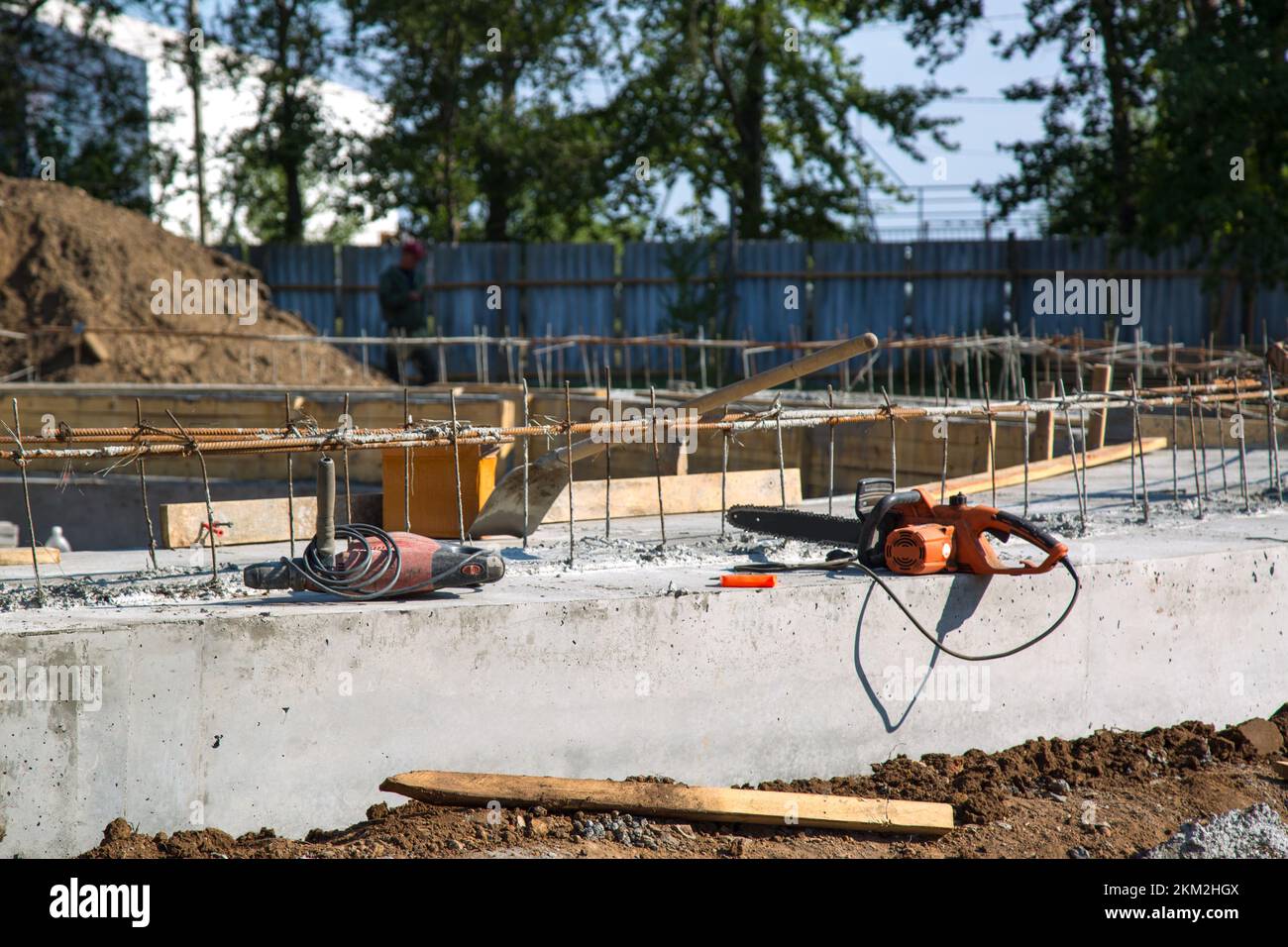 Electric tool on the concrete foundation of a huge fenced construction ...