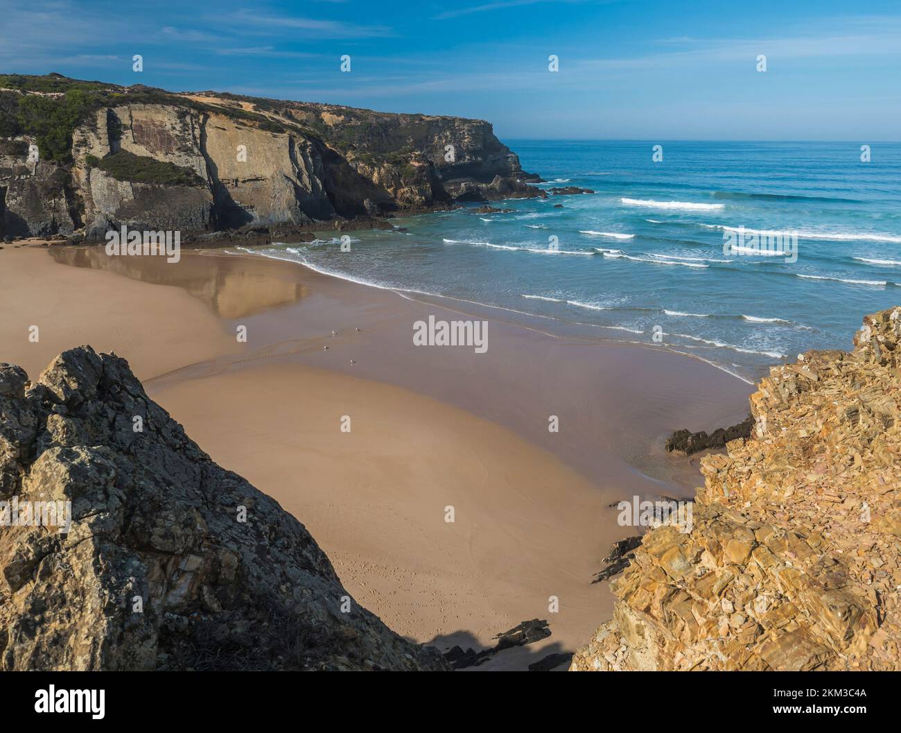 View of empty Praia do Carvalhal beach with ocean waves, cliffs and ...