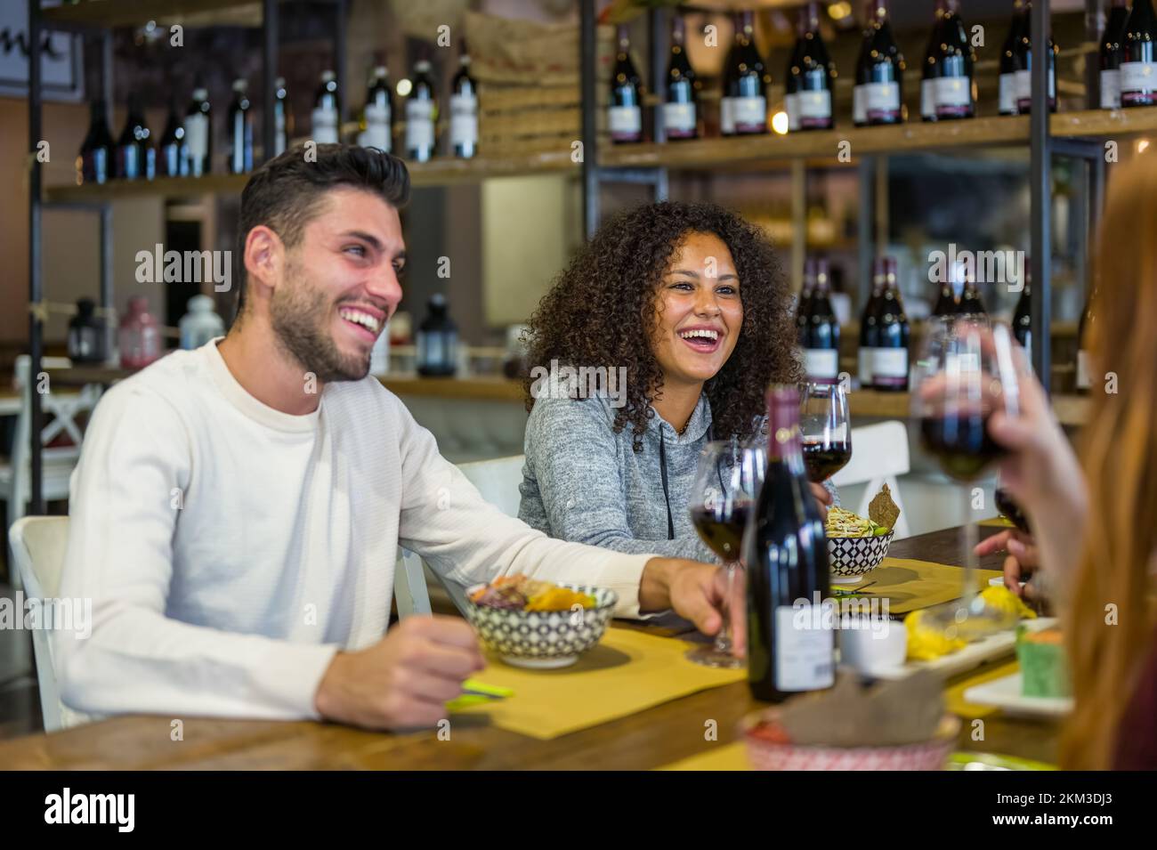 generation z young couple dining at restaurant with friends, focus un ...
