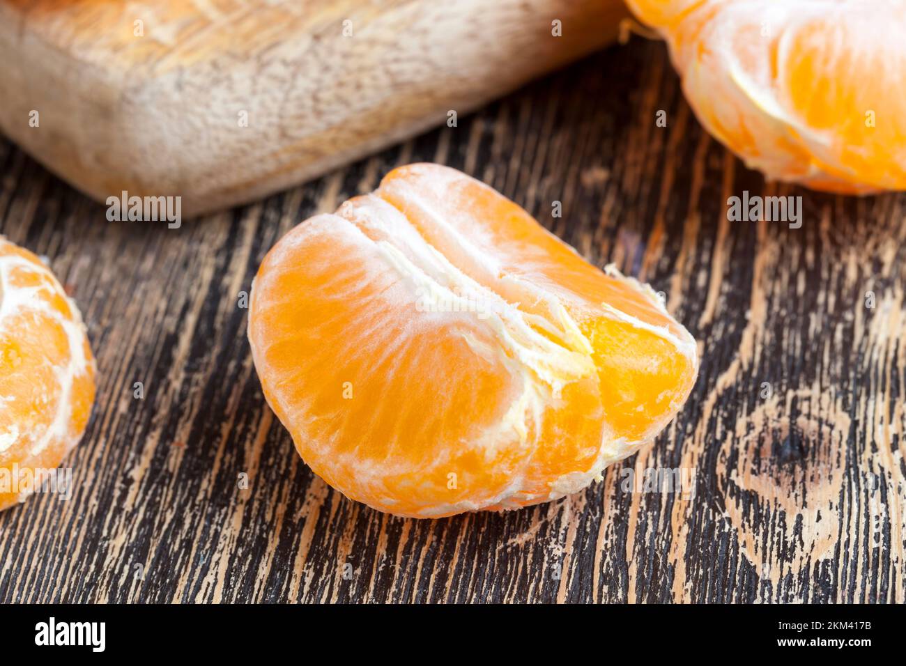peeled ripe juicy tangerine, divided into slices of tangerine on a ...